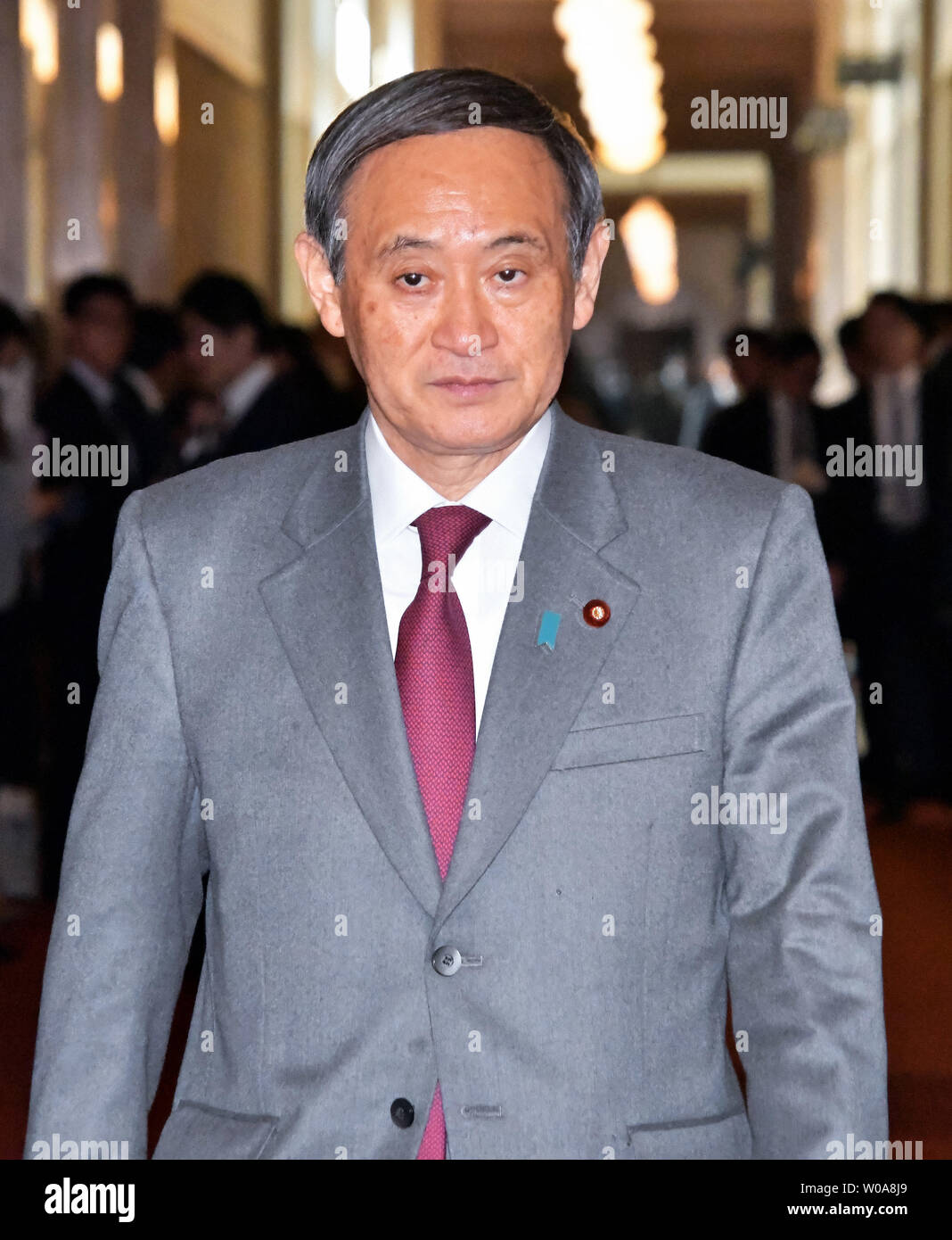 Japan’s Chief Cabinet Secretary Yoshihide Suga walks at the National ...