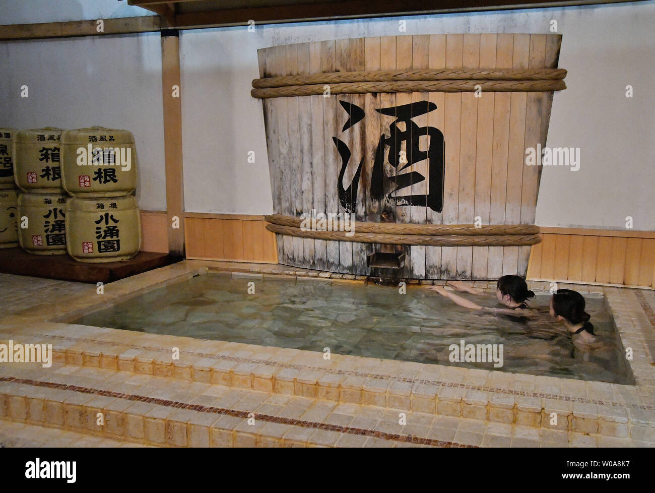 Bathers enjoy in a Japanese Sake bath at a hot springs spa resort in ...