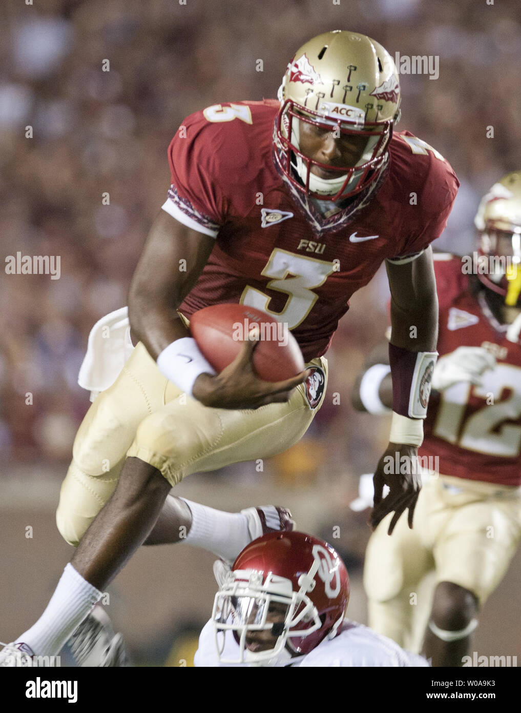 Florida State quarterback EJ Manuel leaps an Oklahoma defender in the ...