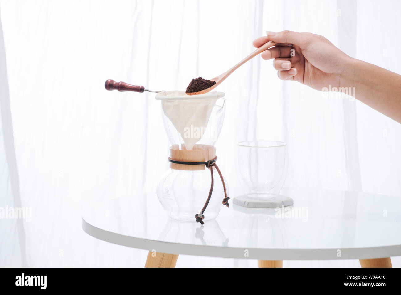 fill grind coffee in filter with wooden spoon Stock Photo - Alamy