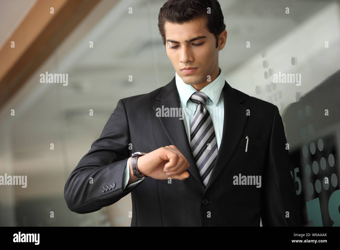 Indian young businessman checking the time Stock Photo - Alamy