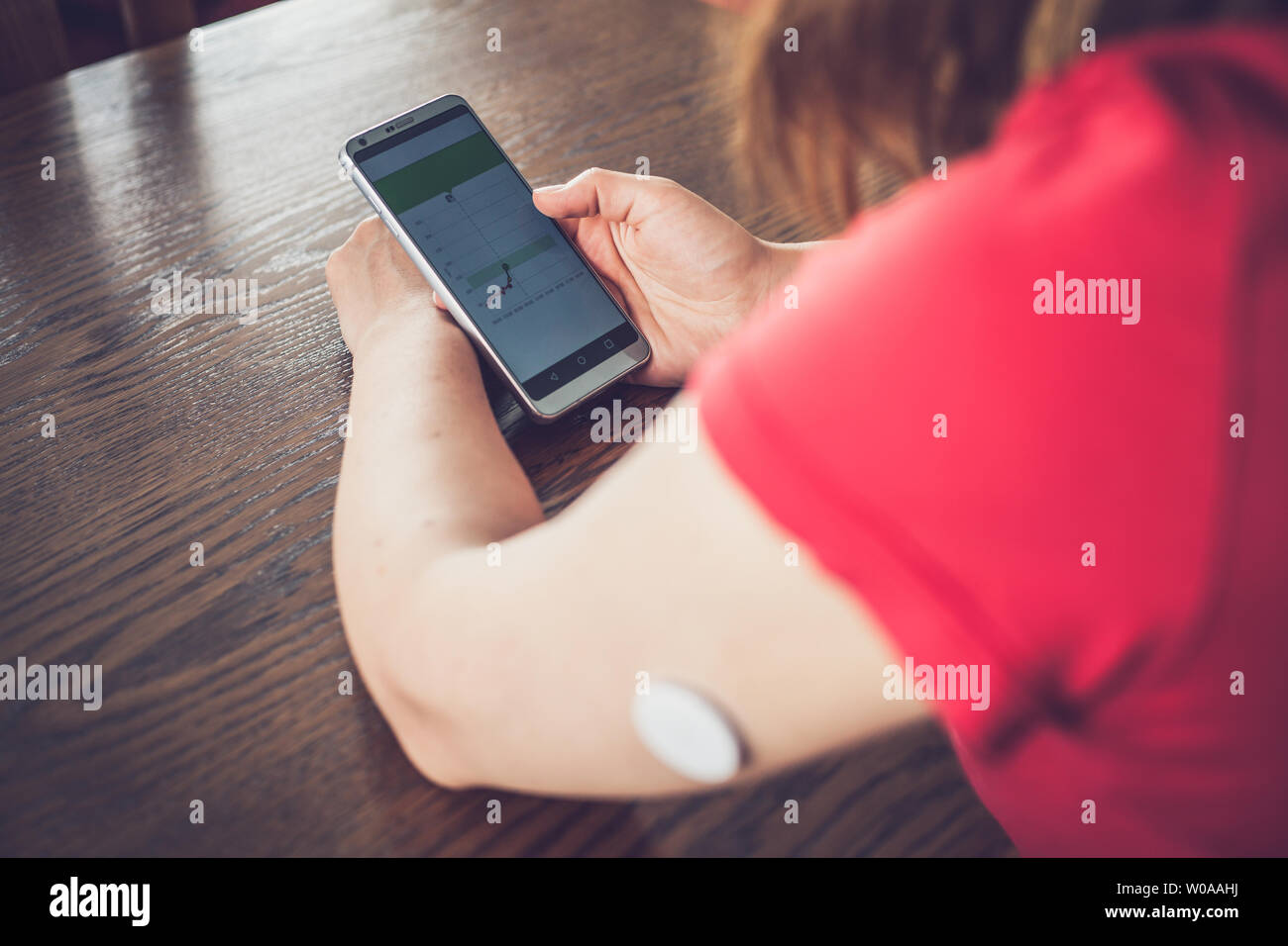 Woman checking glucose level with remote new technology sensor and ...