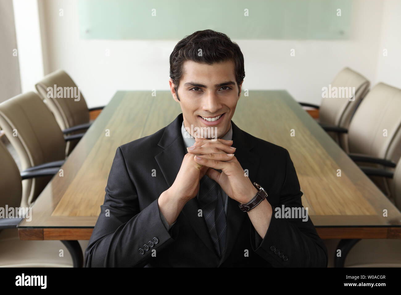 Portrait of a businessman smiling in a conference room Stock Photo - Alamy