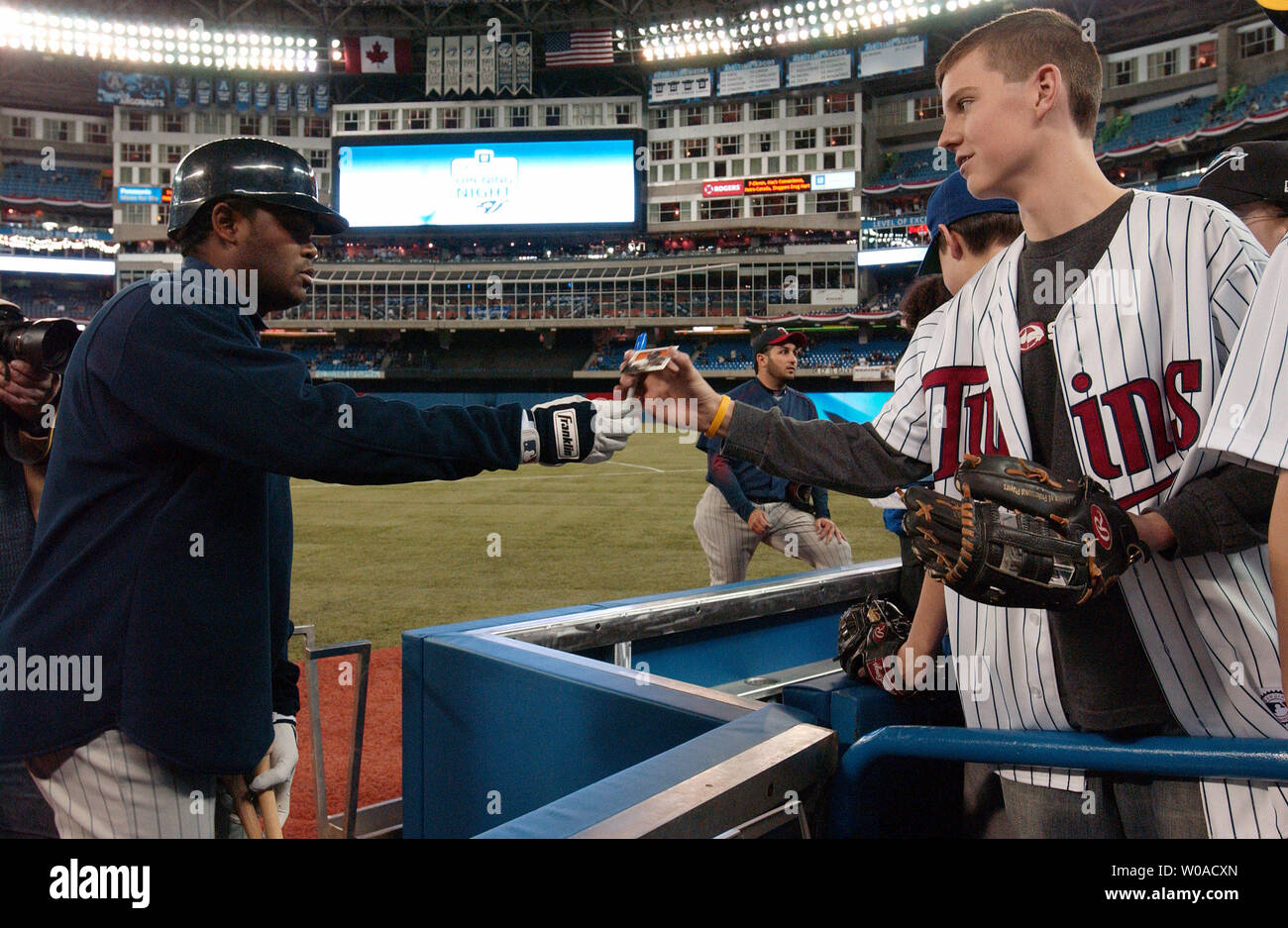 Minnesota Twins' Tony Batista signs autographs for fans before the ...