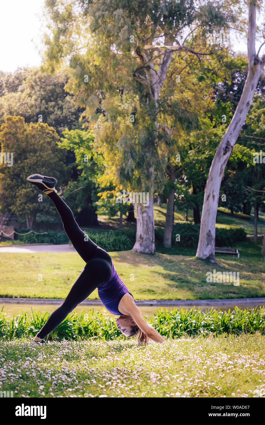 vertical photo of a young sports woman doing meditation yoga balancing ...