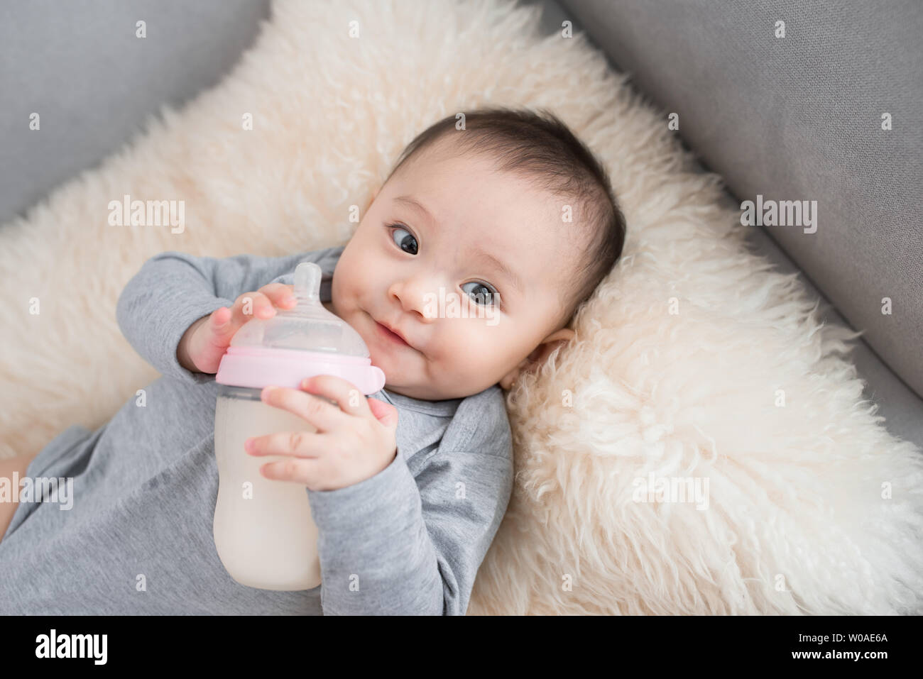 Asian baby infant eating milk from bottle, 9 months after birth Stock ...