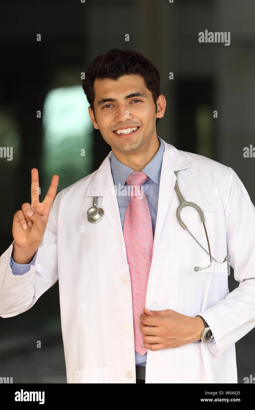 Portrait of a male doctor showing V Sign Stock Photo - Alamy
