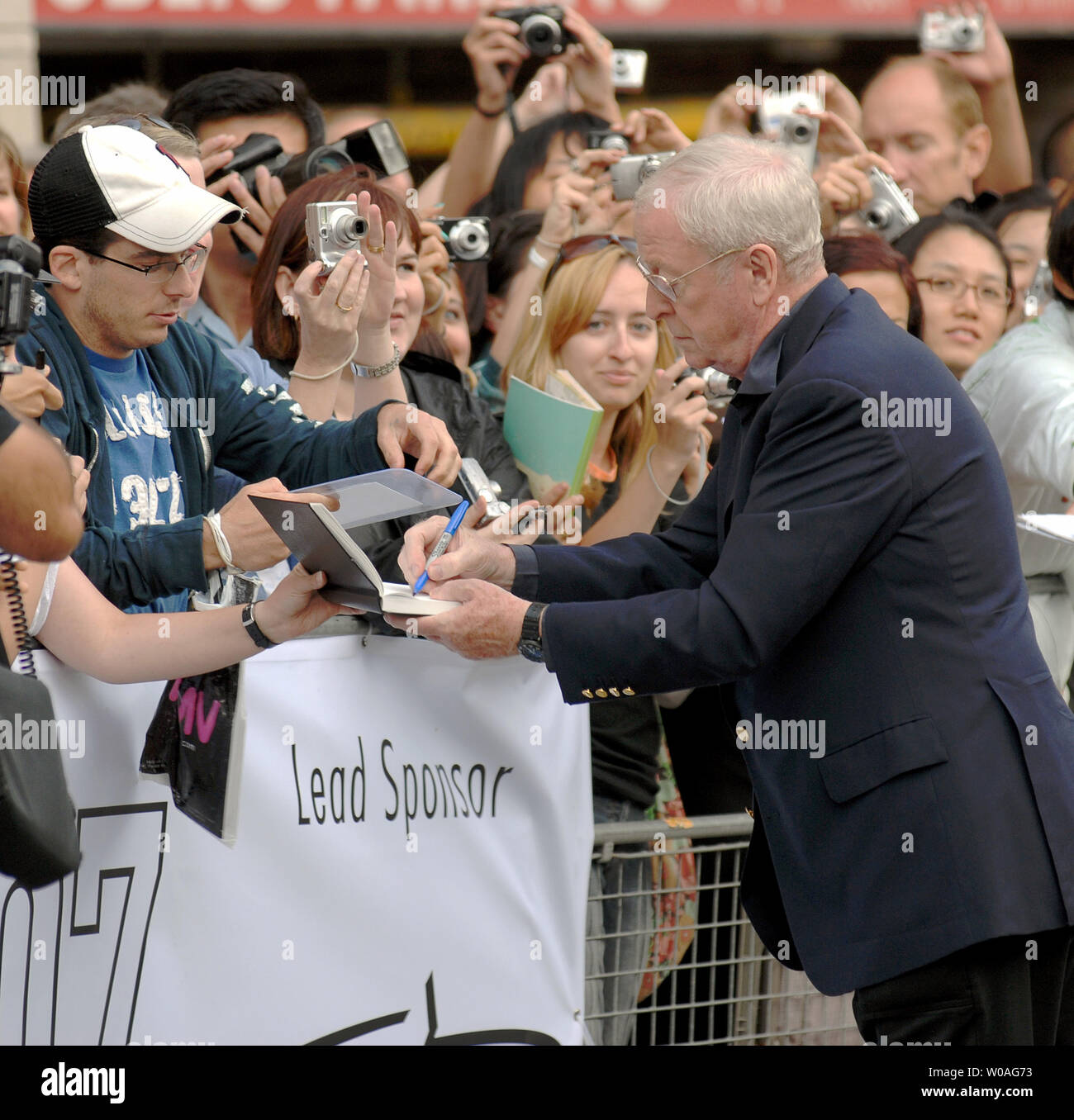 Actor Michael Caine signs autographs for fans as he arrives for the ...