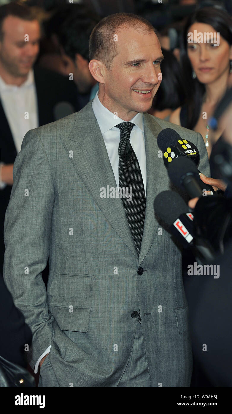 Ralph Fiennes speaks to television reporters on the red carpet as he ...