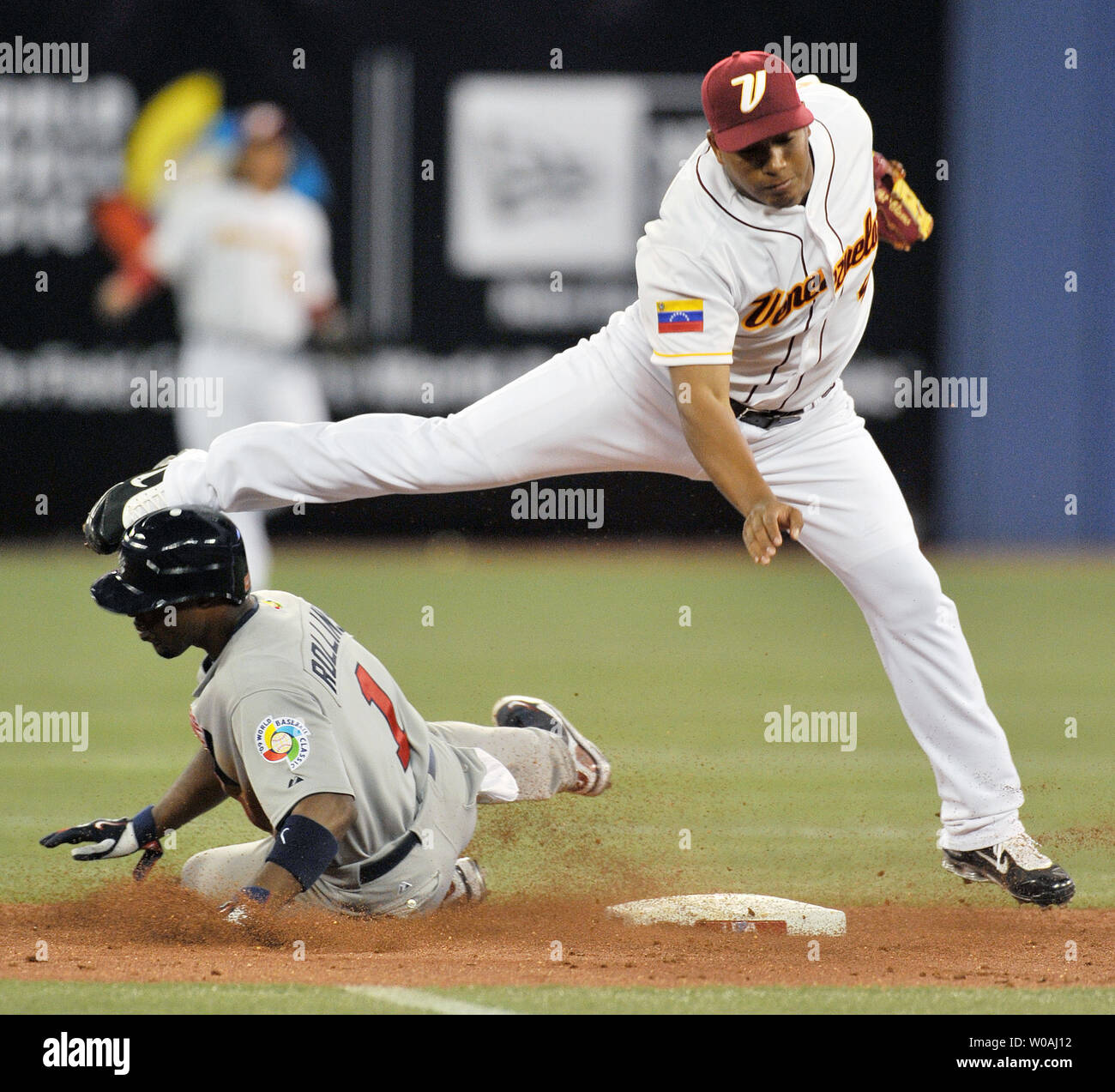 Team Venezuela's Jose Lopez jumps over a sliding Jimmy Rollins (no. 1 ...