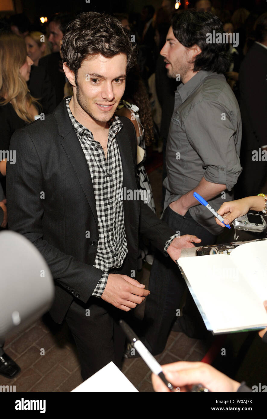 Actor Adam Brody signs autographs for fans as he arrives for the ...