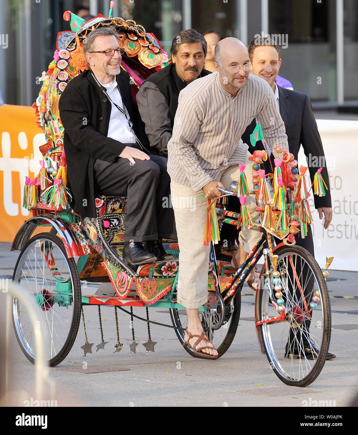 Director Dilip Mehta (center) arrives in a rickshaw for the Toronto ...