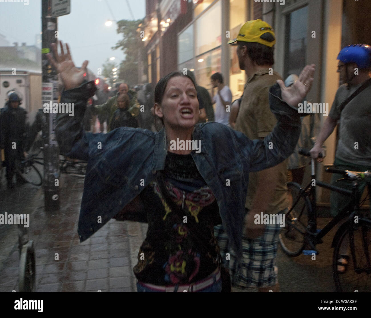 An anti G8, G20 protestor throws up her hands in frustration as riot ...
