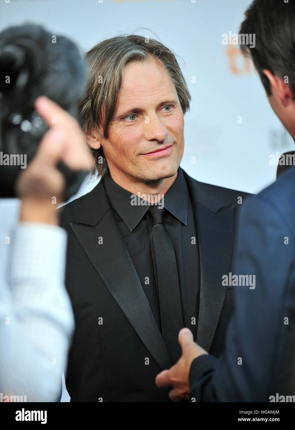 Actor Viggo Mortensen speaks with television reporters on the red ...