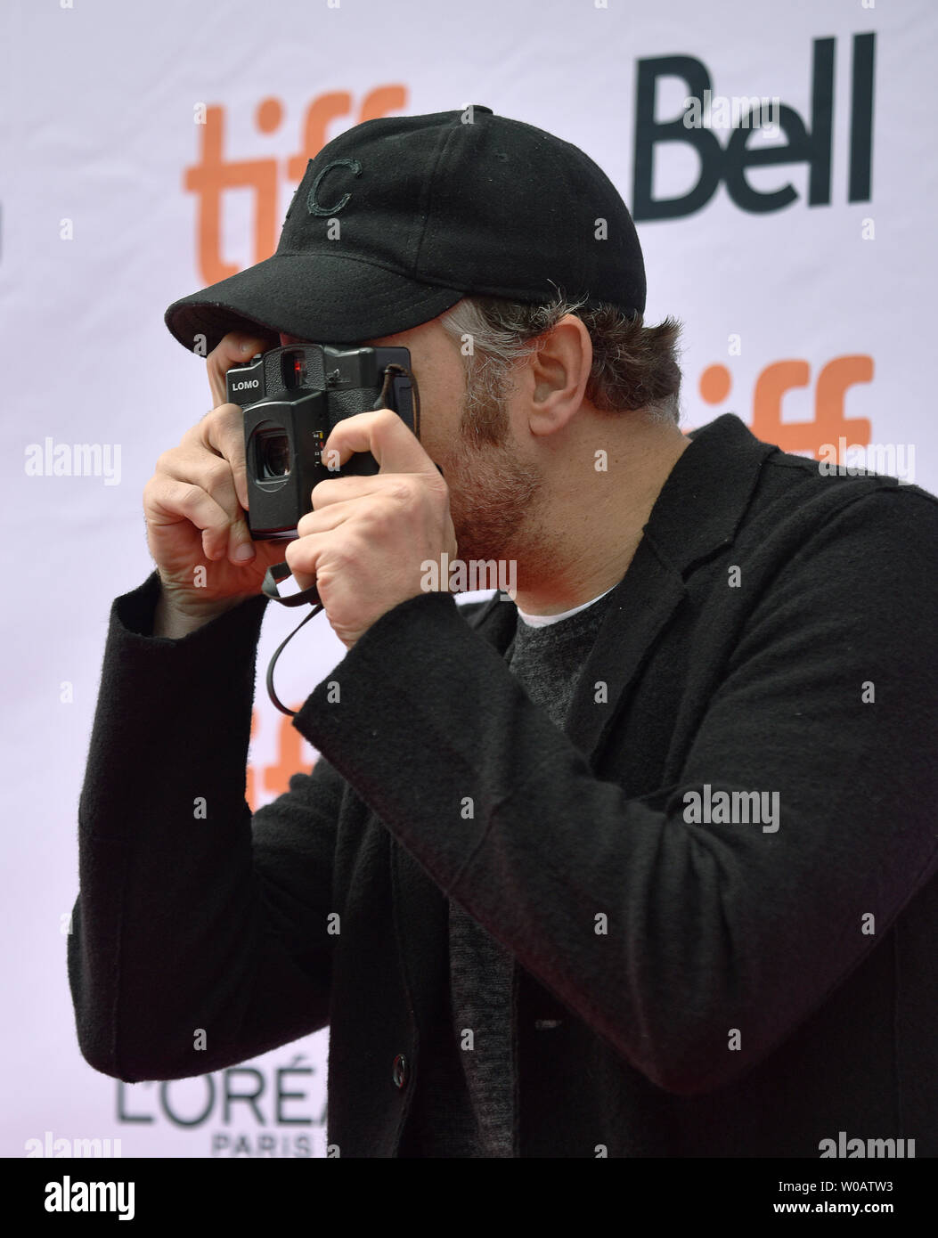 Jason Sudeikis takes a photo of photographers on the red carpet as he ...