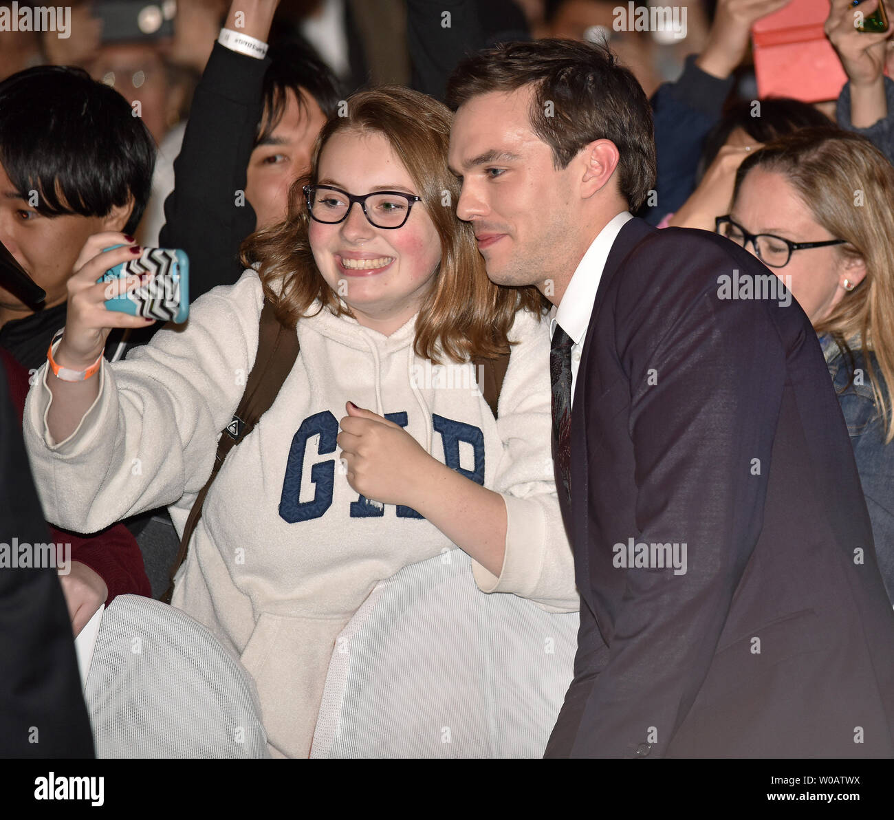 Nicholas Hoult poses for a selfie with fans as he arrives for the world ...