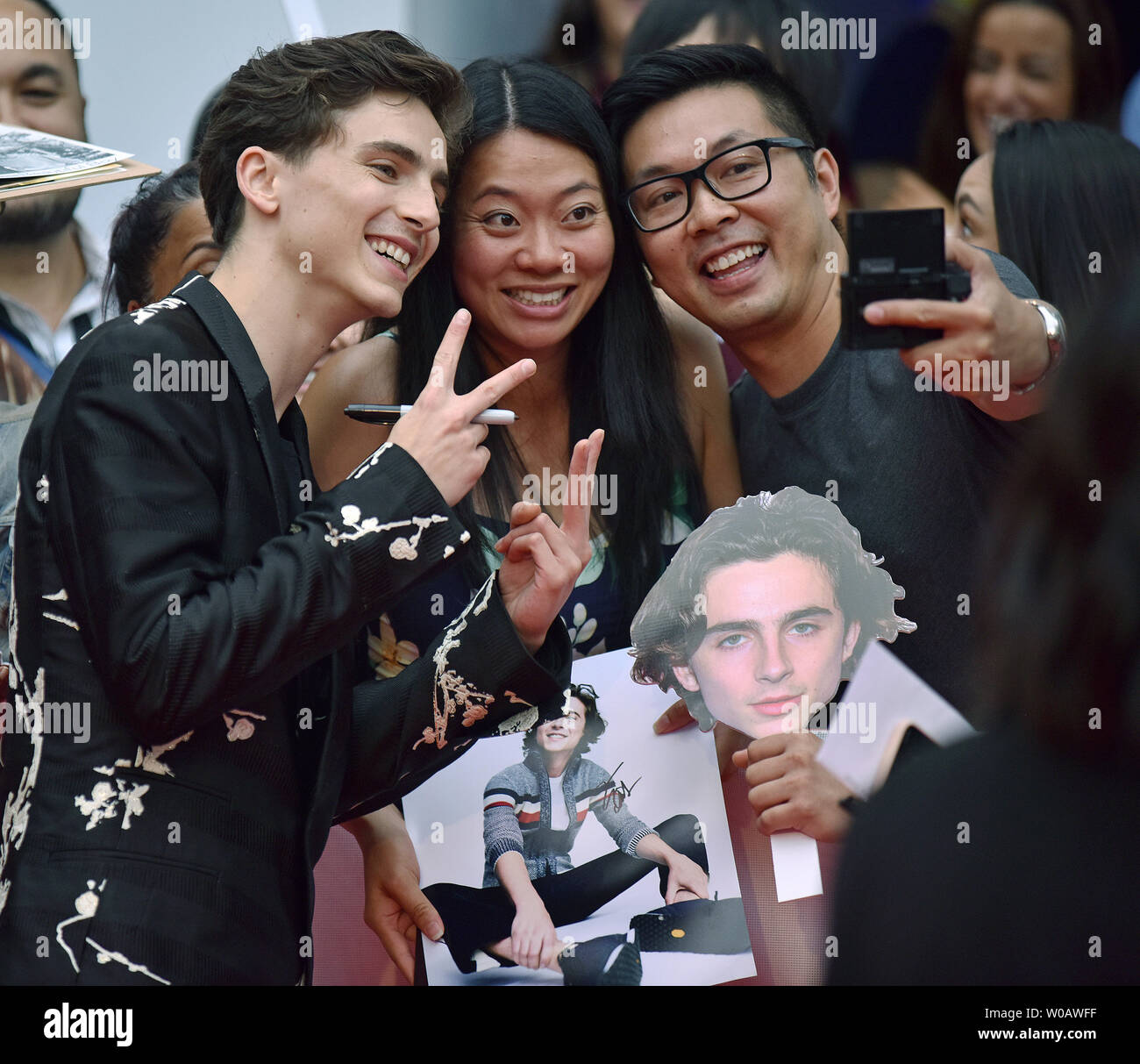 Timothee Chalamet takes a selfie with fans as he arrives for the world ...