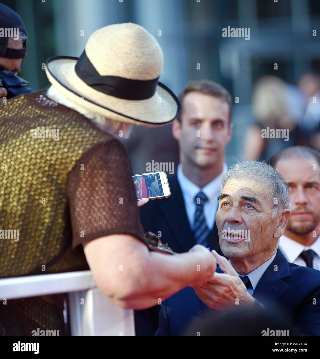 Robert Forster (R) signs autographs for fans as he arrives for the ...