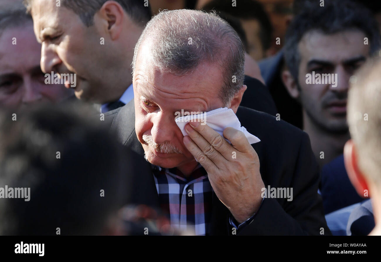Turkish President Recep Tayyip Erdogan wipes his tears as he attends ...