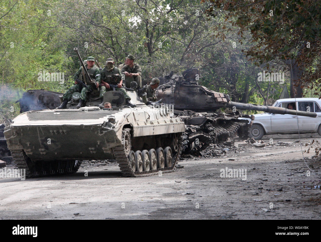 Russian soldiers roll past a destroyed Georgian tank in the center of ...