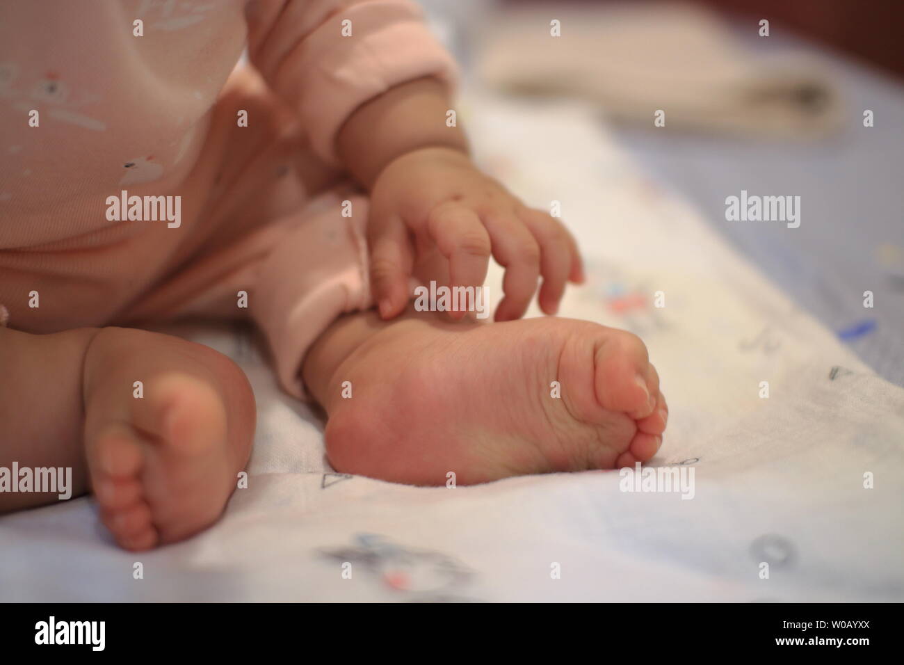 small baby sitting. close up image of baby leg and feet. healthy and ...