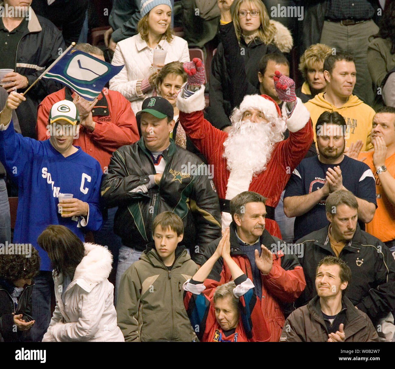 A fan dressed as Santa Claus cheers at a NHL game between the visiting ...