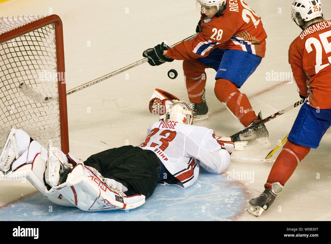 Team Canada's goalie Justin Pogge makes a reaching glove save ahead of ...