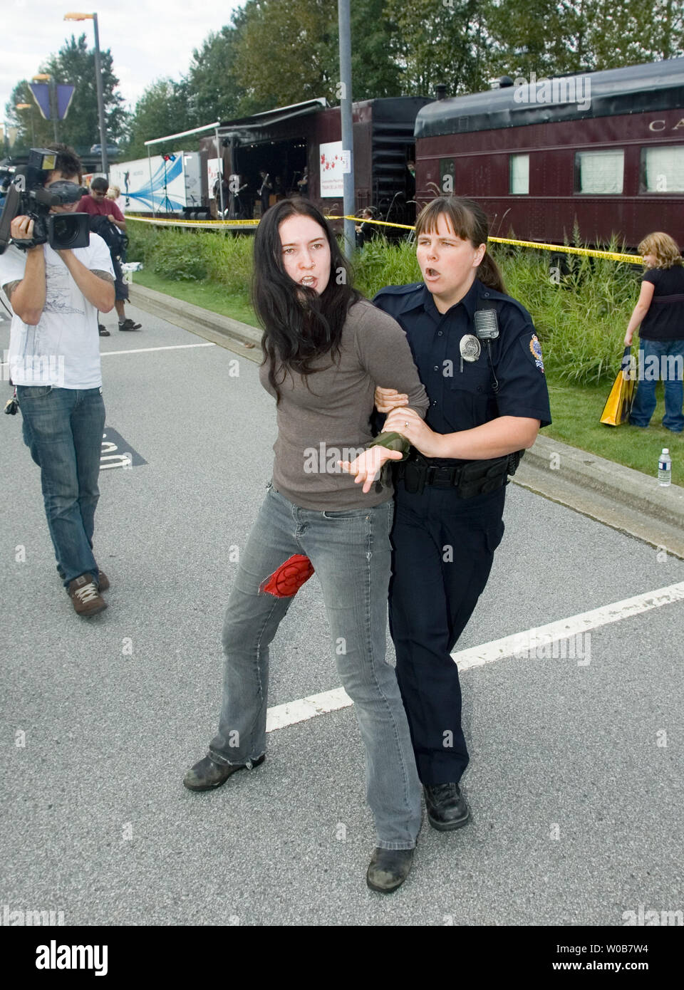 A female protester is restrained after she tries to stop police ...