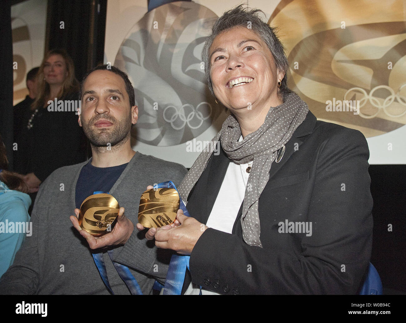 Designer Omer Arbel (L) holds the Olympic gold medal while local First ...
