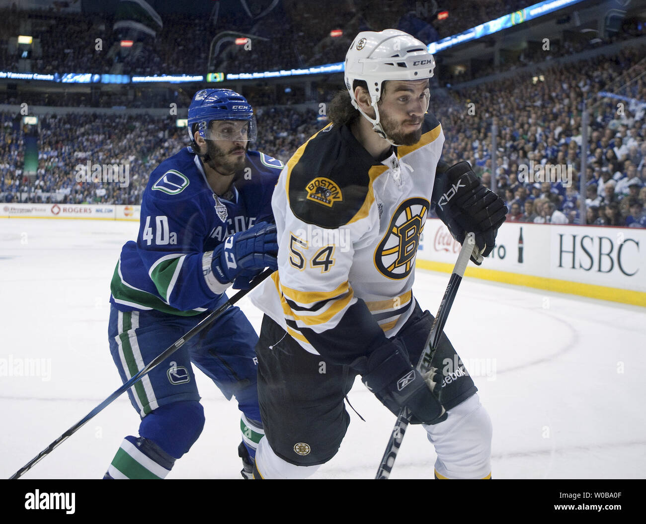 Boston Bruins Adam McQuaid looks for the puck ahead of Vancouver ...