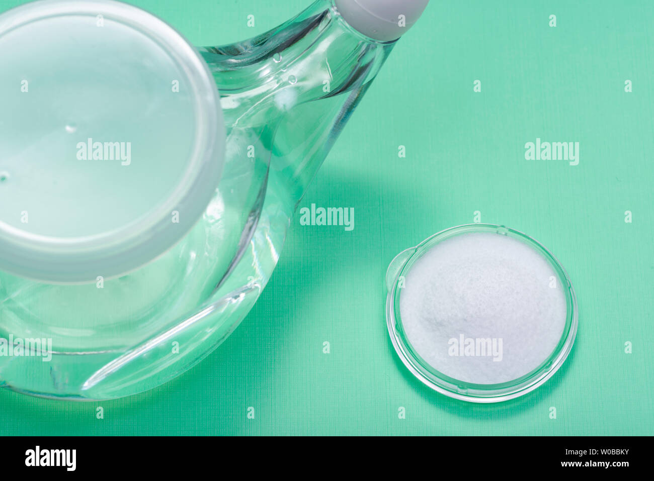 Neti Pot with Soft Comfort Tip and pile of saline (sodium bicarbonate ...