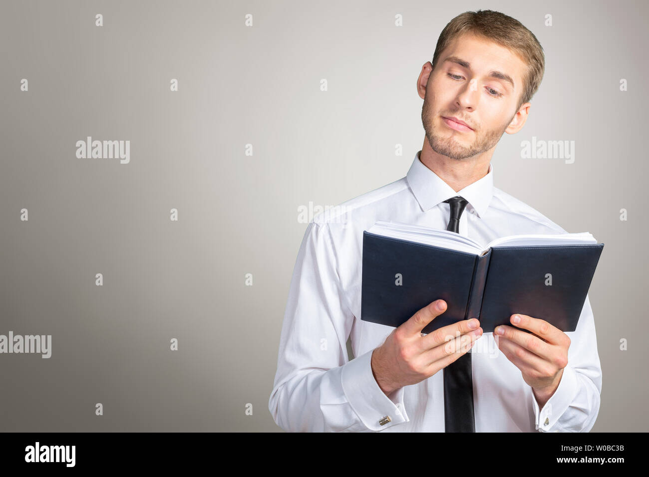 Handsome young business man reading a book Stock Photo - Alamy