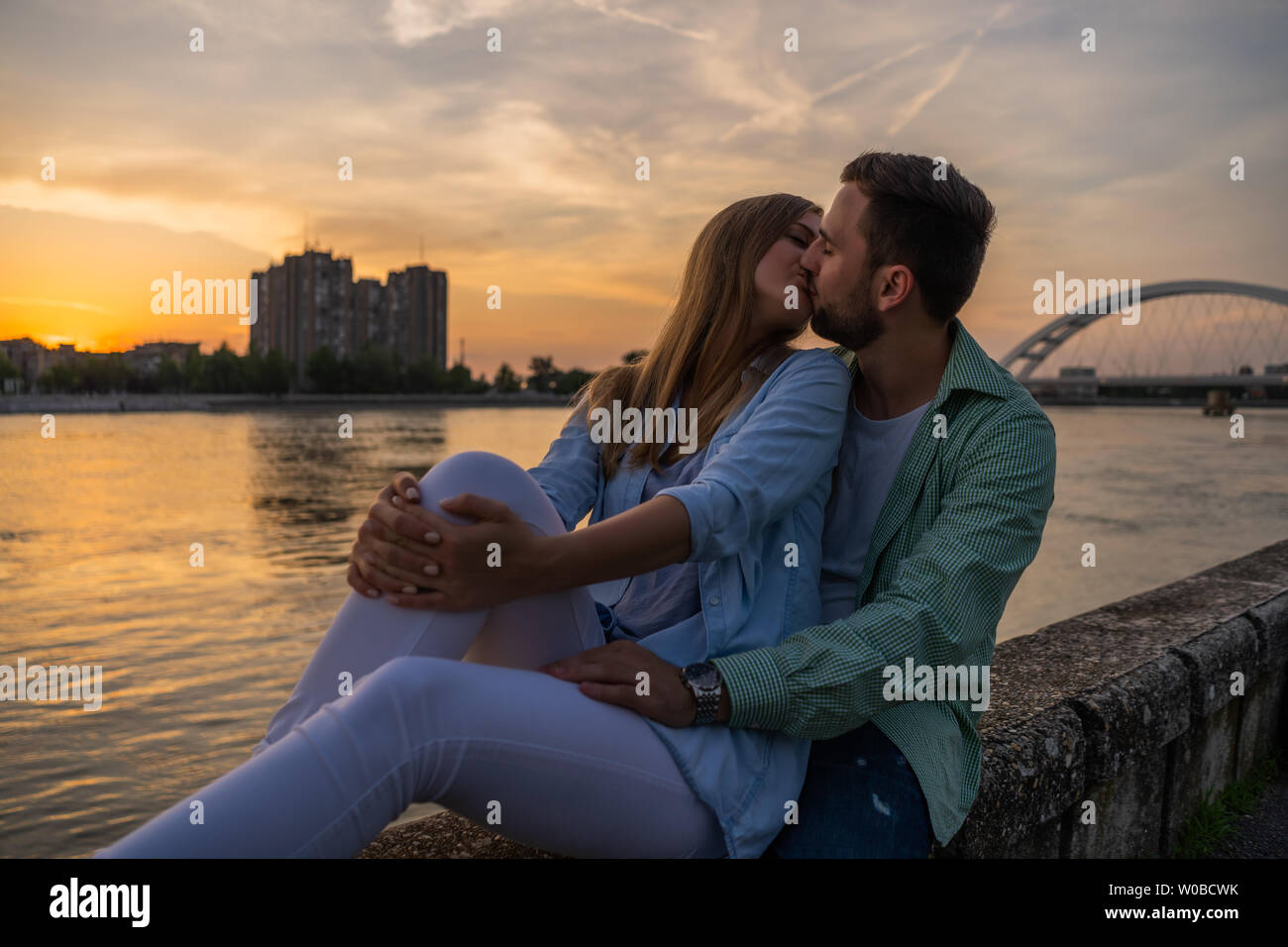 Happy couple in love kissing at river bank in the city Stock Photo - Alamy