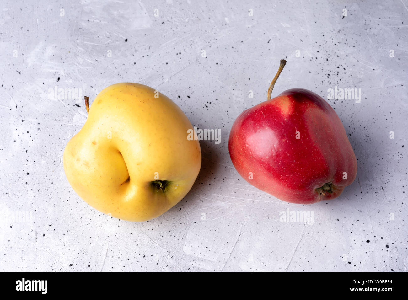 Two ugly red and yellow apples on grey concrete background Stock Photo ...