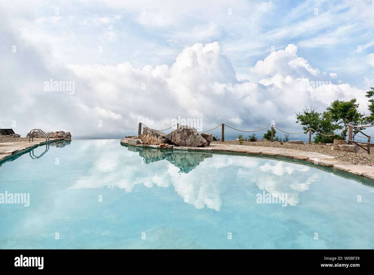 Beautiful swimming pool in the edge of plateau with sky and clouds ...
