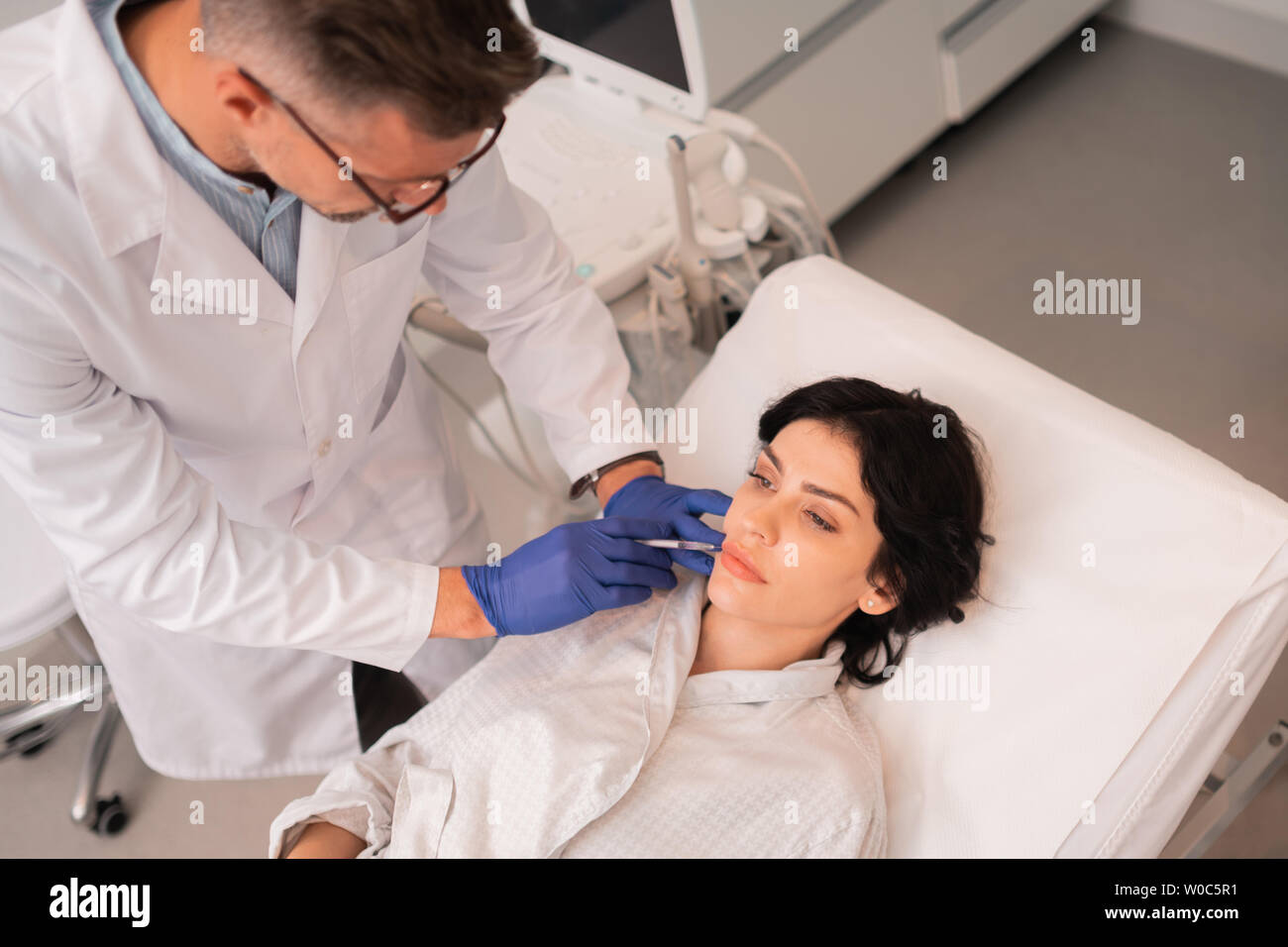 Plastic surgeon wearing gloves making botox injections Stock Photo - Alamy
