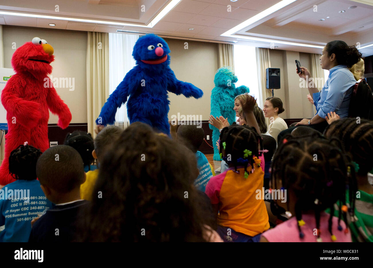 Children watch a performance by Sesame Street's Elmo, Rosita and Grover ...
