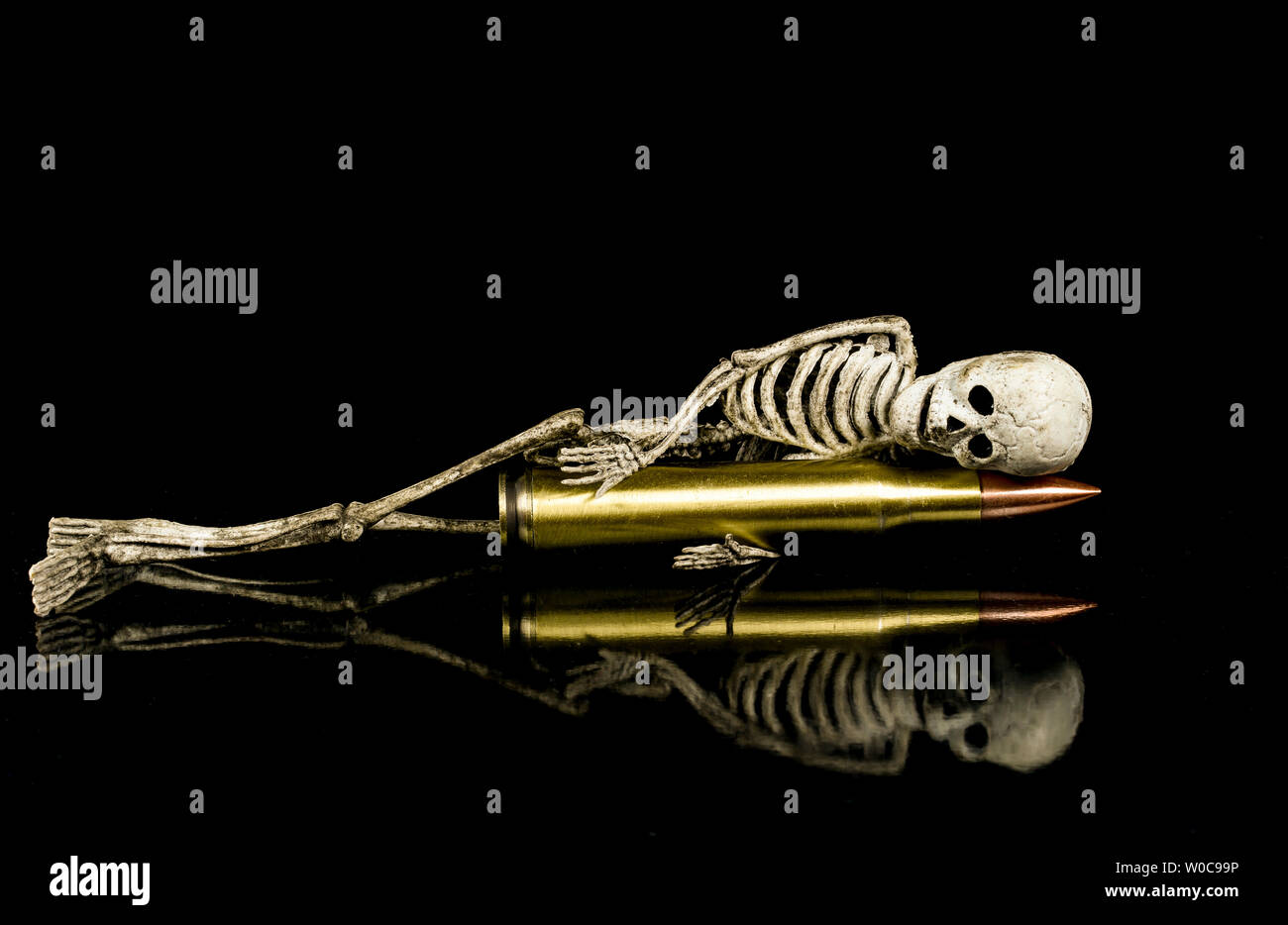 Plastic human like skeleton embracing a high caliber bullet ...