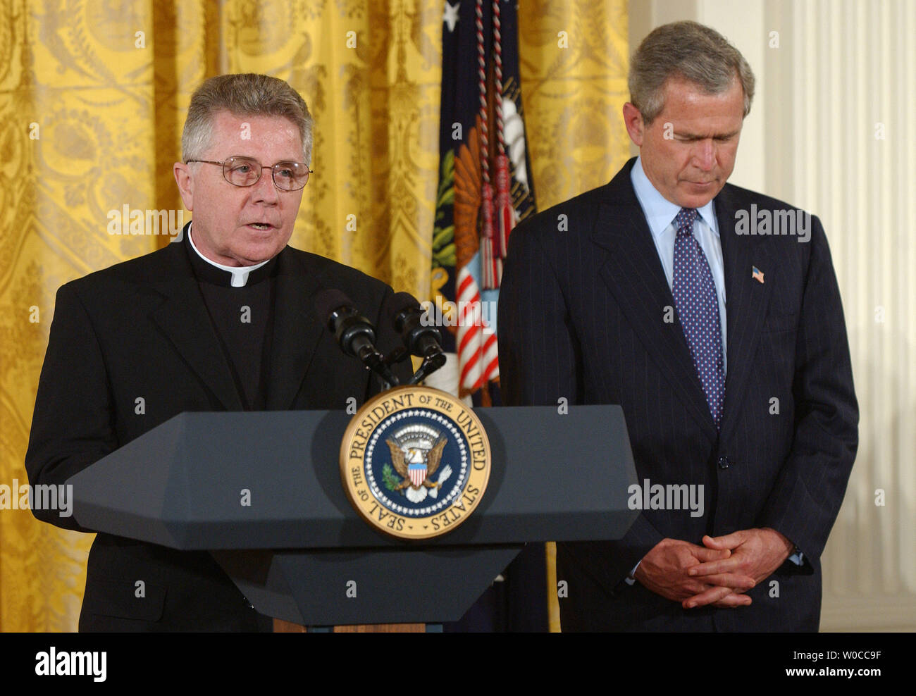 President George W. Bush bows his head in prayer as U.S. House ...