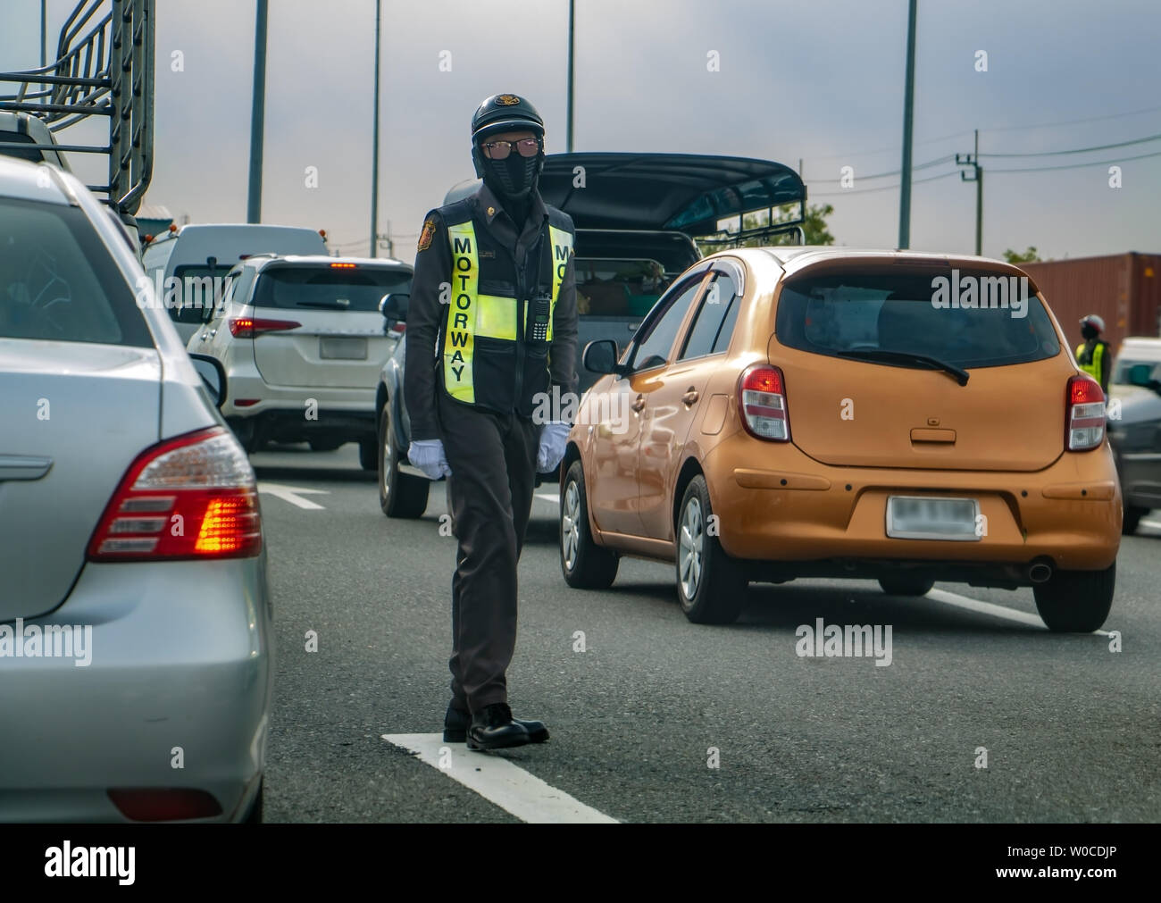 A police man with a face mask checks the traffic on the highway ...