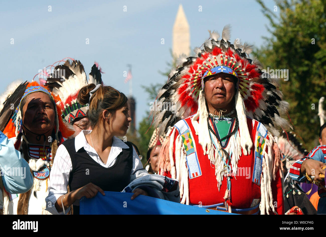 Native Americans wearing traditional garb parade down the National Mall ...