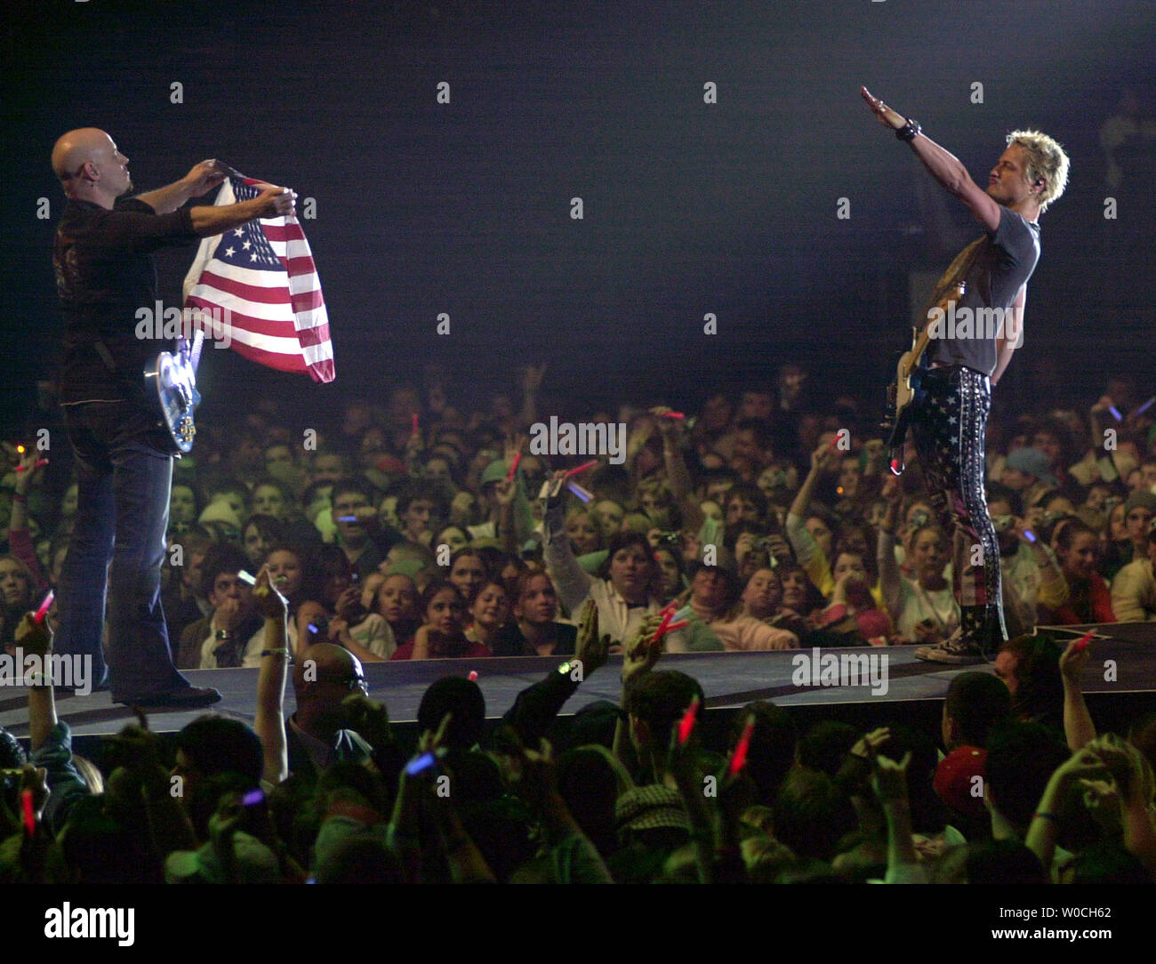 Lead singer Brett Scallions of Fuel salutes the American flag held by a ...
