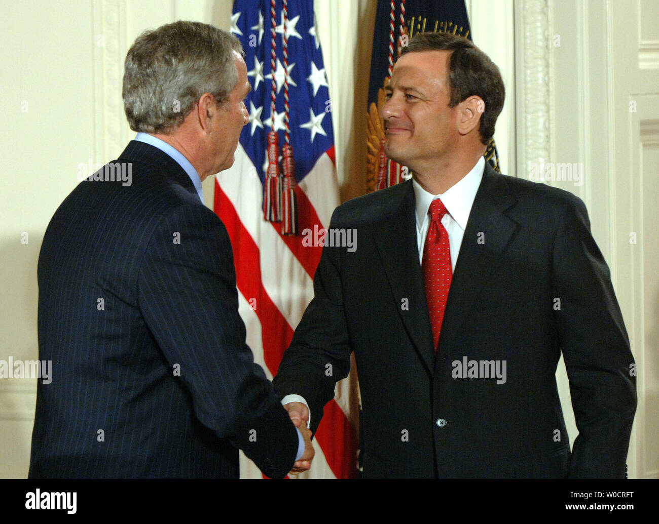 Judge John Roberts shakes hands with U.S. President George W. Bush ...