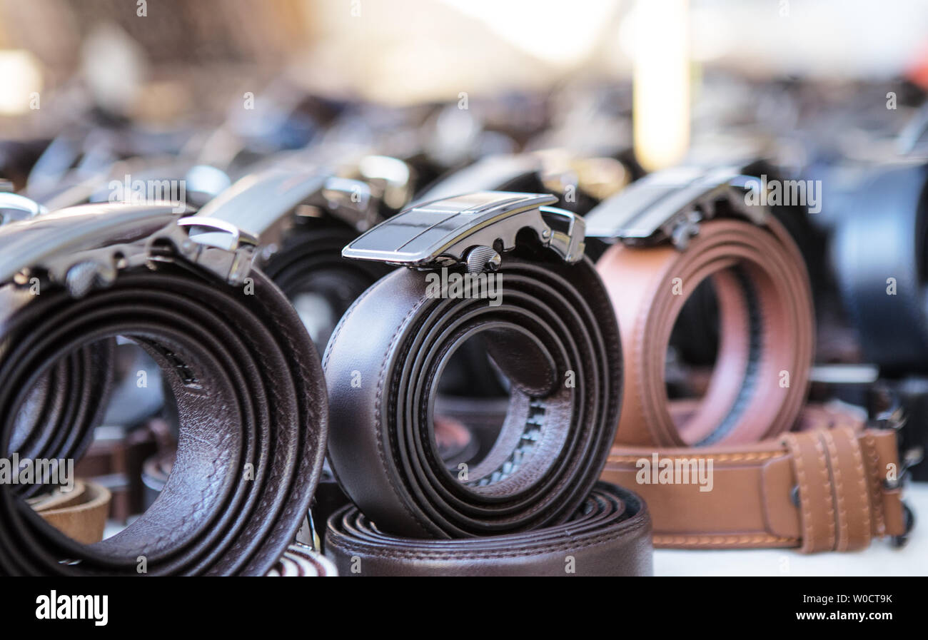 lots of rolled up leather belts for sale on a market stand Stock Photo ...