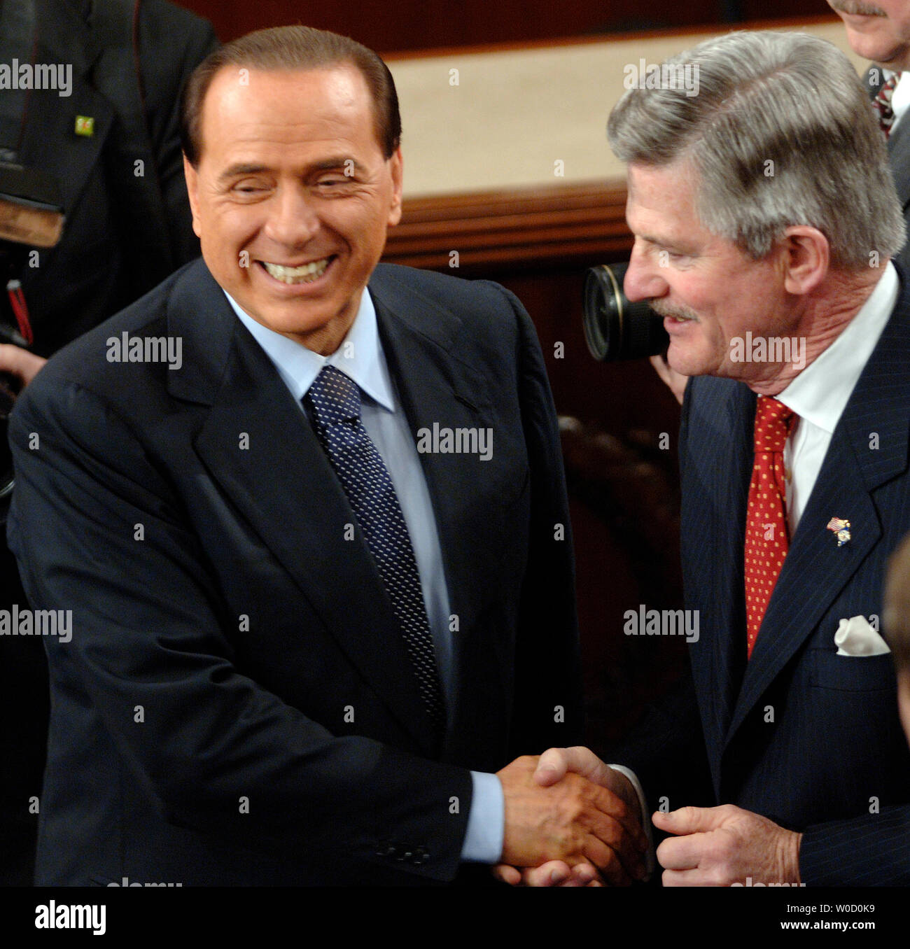Italian Prime Minister Silvio Berlusconi (L) shakes hands with ...