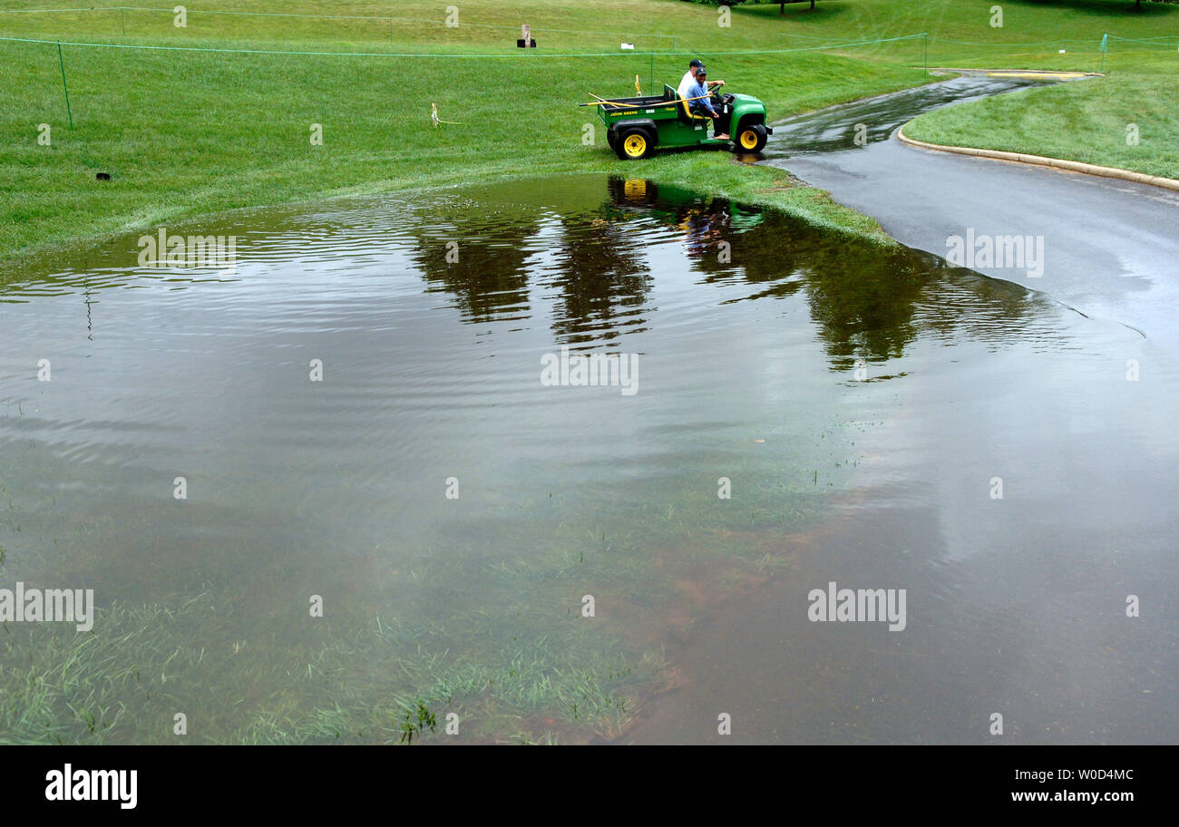 A cart attempts to drive through a puddle near the fourteenth green ...