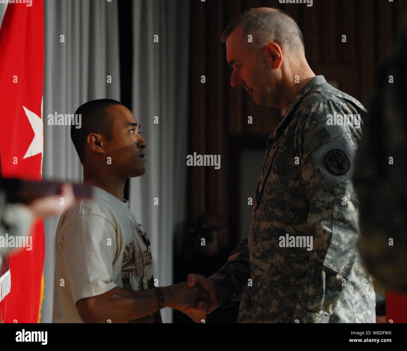 Brigadier Gen. Michael Tucker (L) shakes hands with Sgt. Aeron Rimando ...
