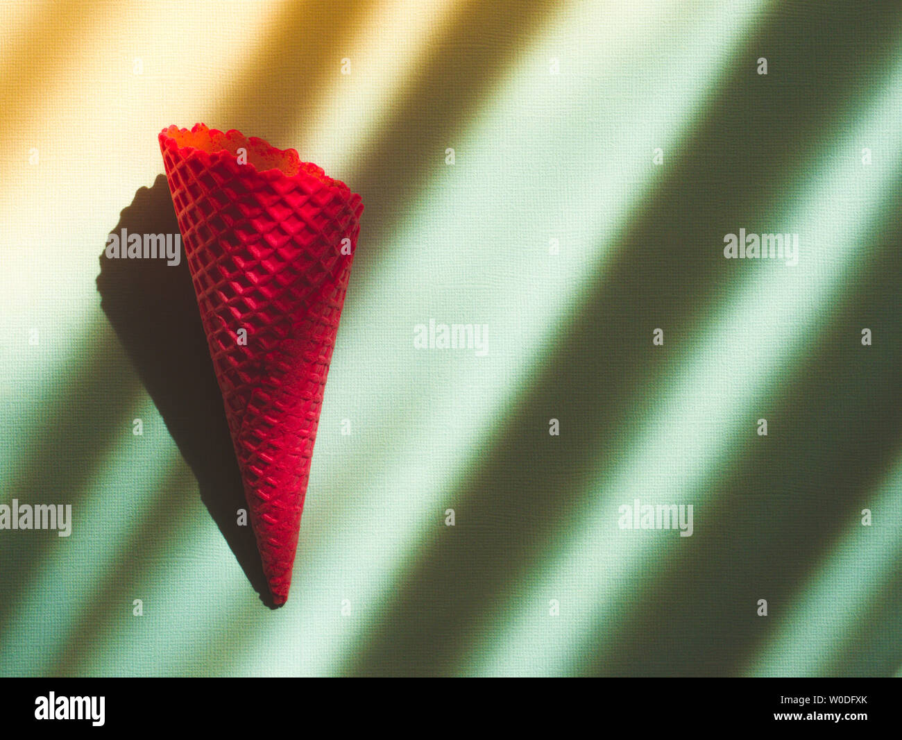 Red ice cream cone on light blue background with shadows Stock Photo ...