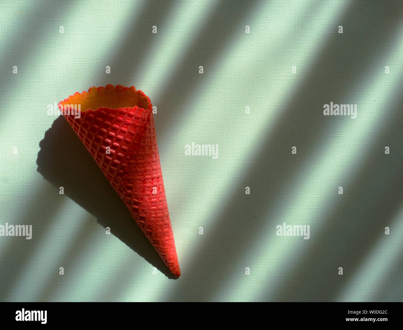 Red ice cream cone on light blue background with shadows Stock Photo ...