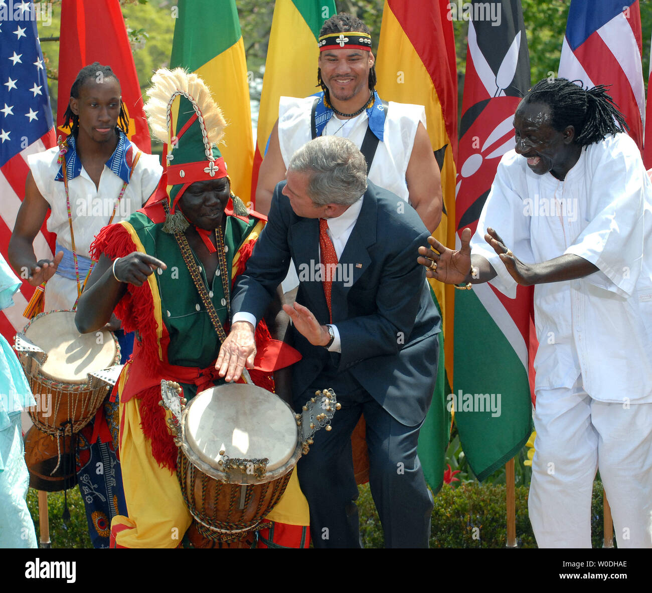 U.S. President George W. Bush plays a drum with Medoun Yacine Gueye ...